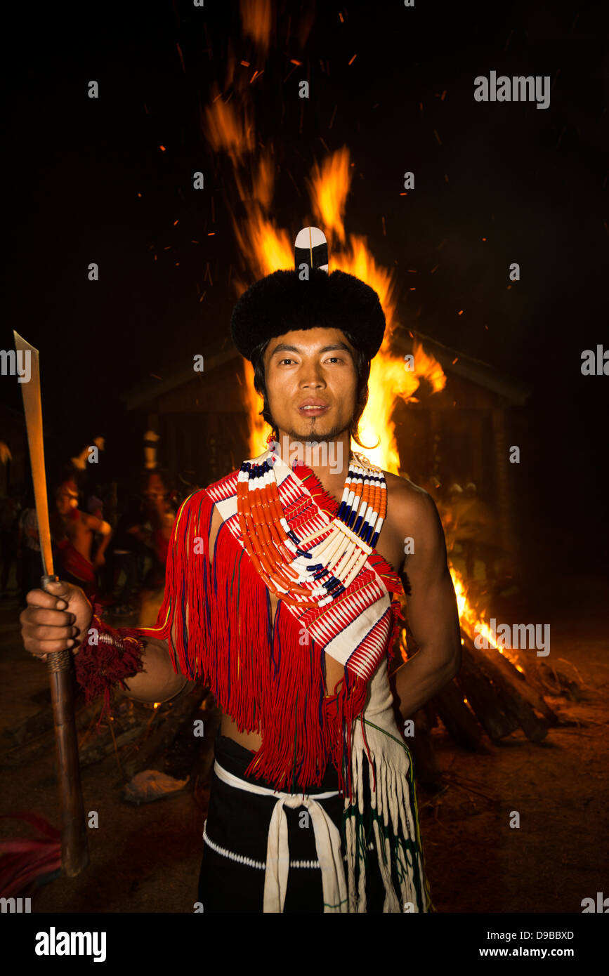 Naga tribesman holding a machete in front of fire during the annual ...