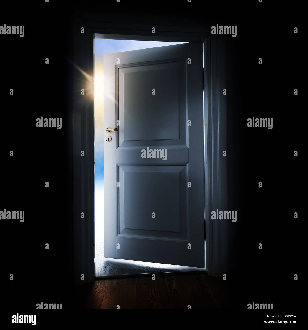 Opening blue door in a dark room with shining light and sky outside ...