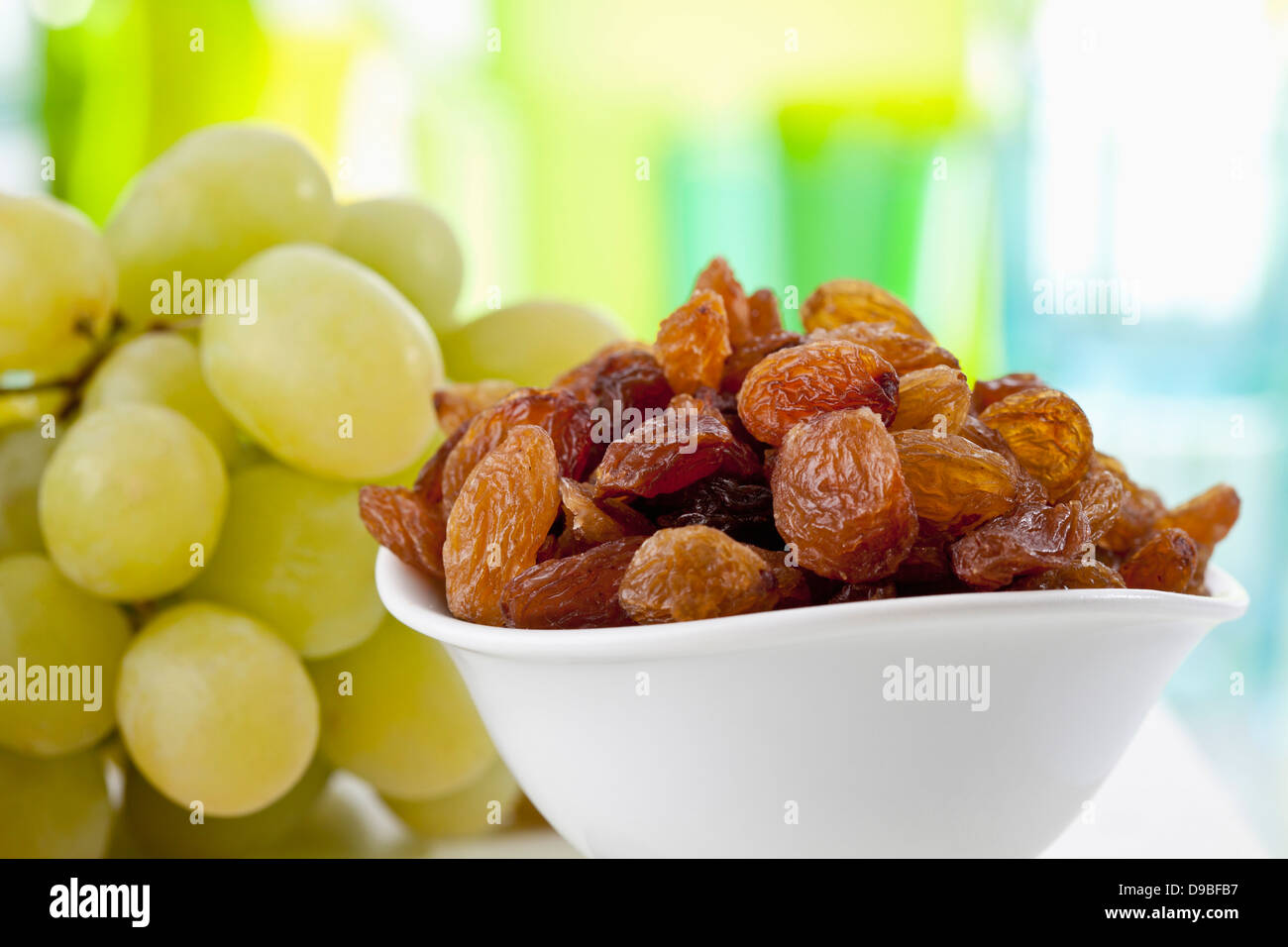 Bowl of sultanas with green grapes on white background, close up Stock ...