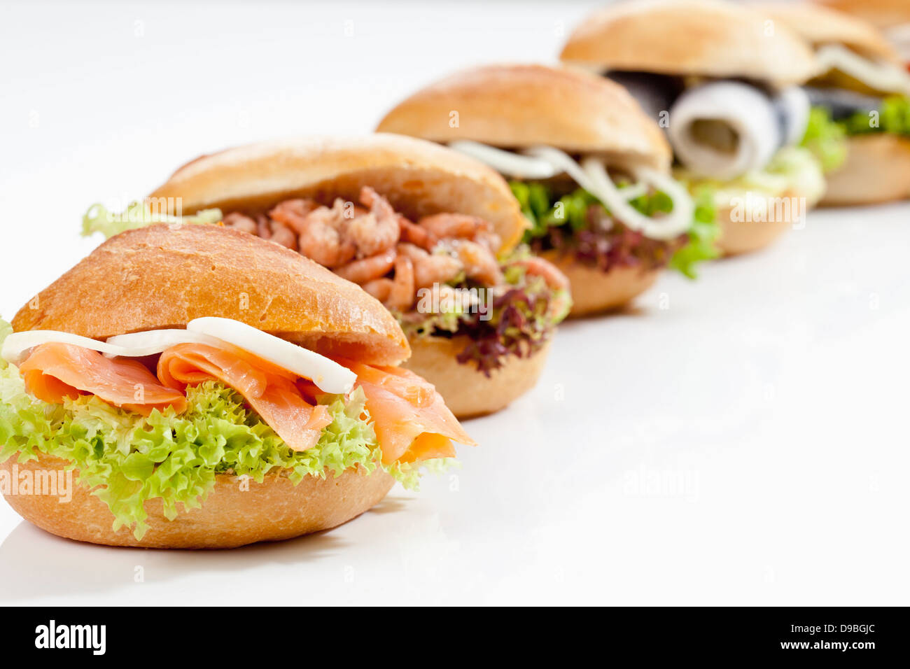 Varieties of bread rolls with fish on white background, close up Stock ...