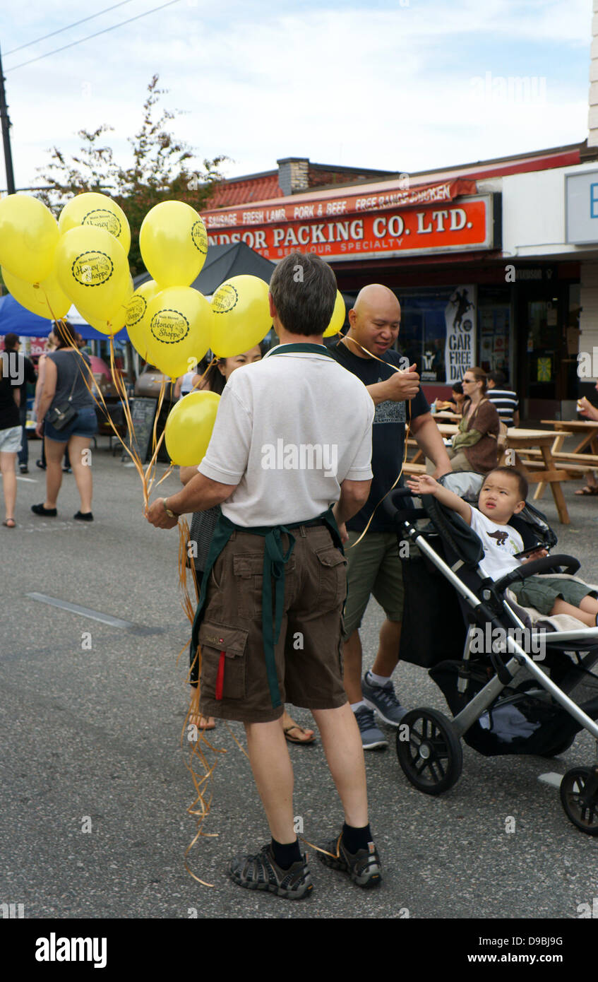 Man giving out yellow balloons at the Car Free Day festival on Main ...