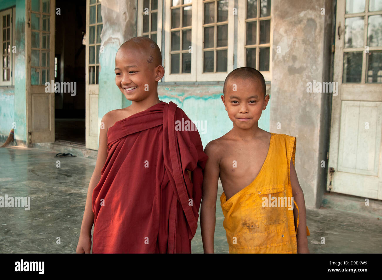 Two boy Buddhist monks smiling in front of monastery doorway Myanmar ...