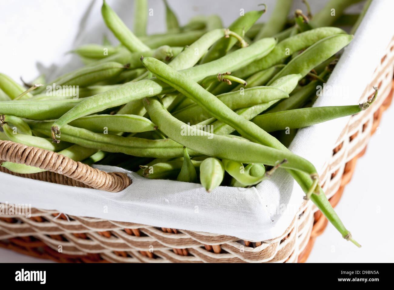 Bush beans in basket on white background, close up Stock Photo - Alamy