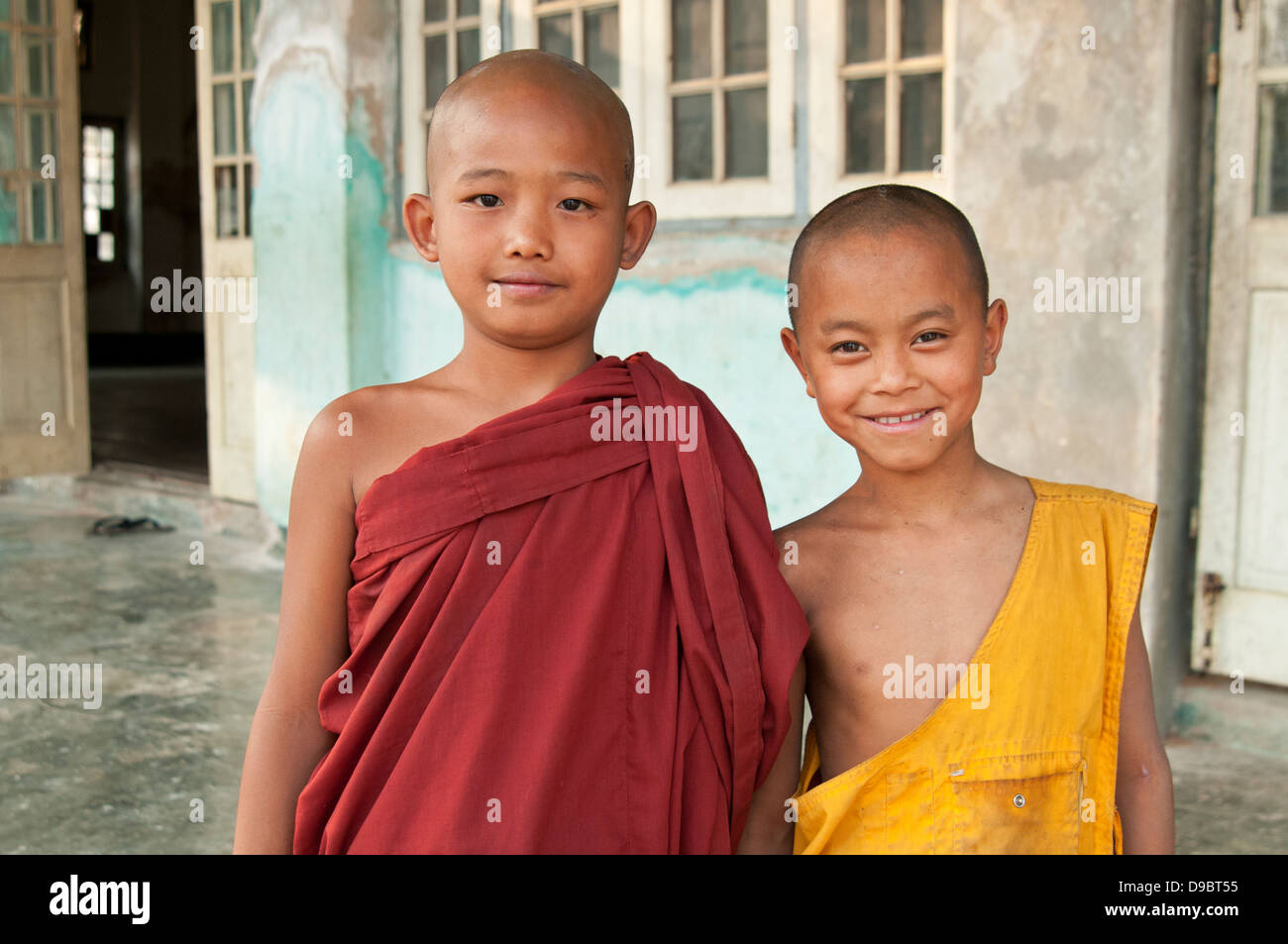 Two boy Buddhist monks smiling in front of monastery doorway Myanmar ...