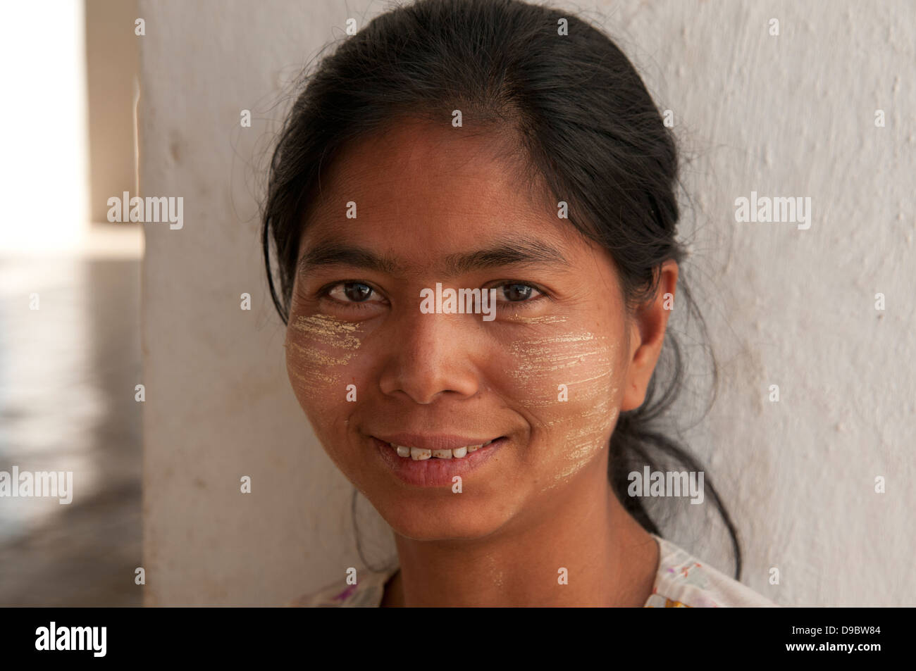 Portrait of a pretty Burmese woman with face covered in thanakha ...