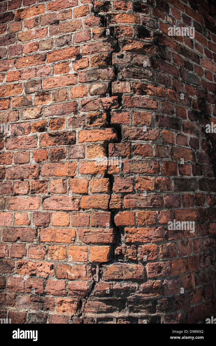 Brick building structure with a large crack running down the center ...