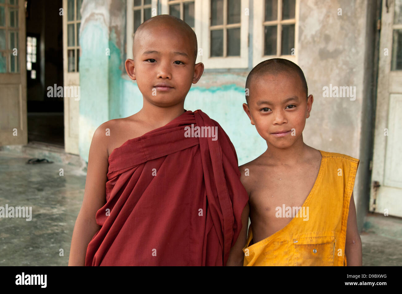 Two boy Buddhist monks smiling in front of monastery doorway Myanmar ...