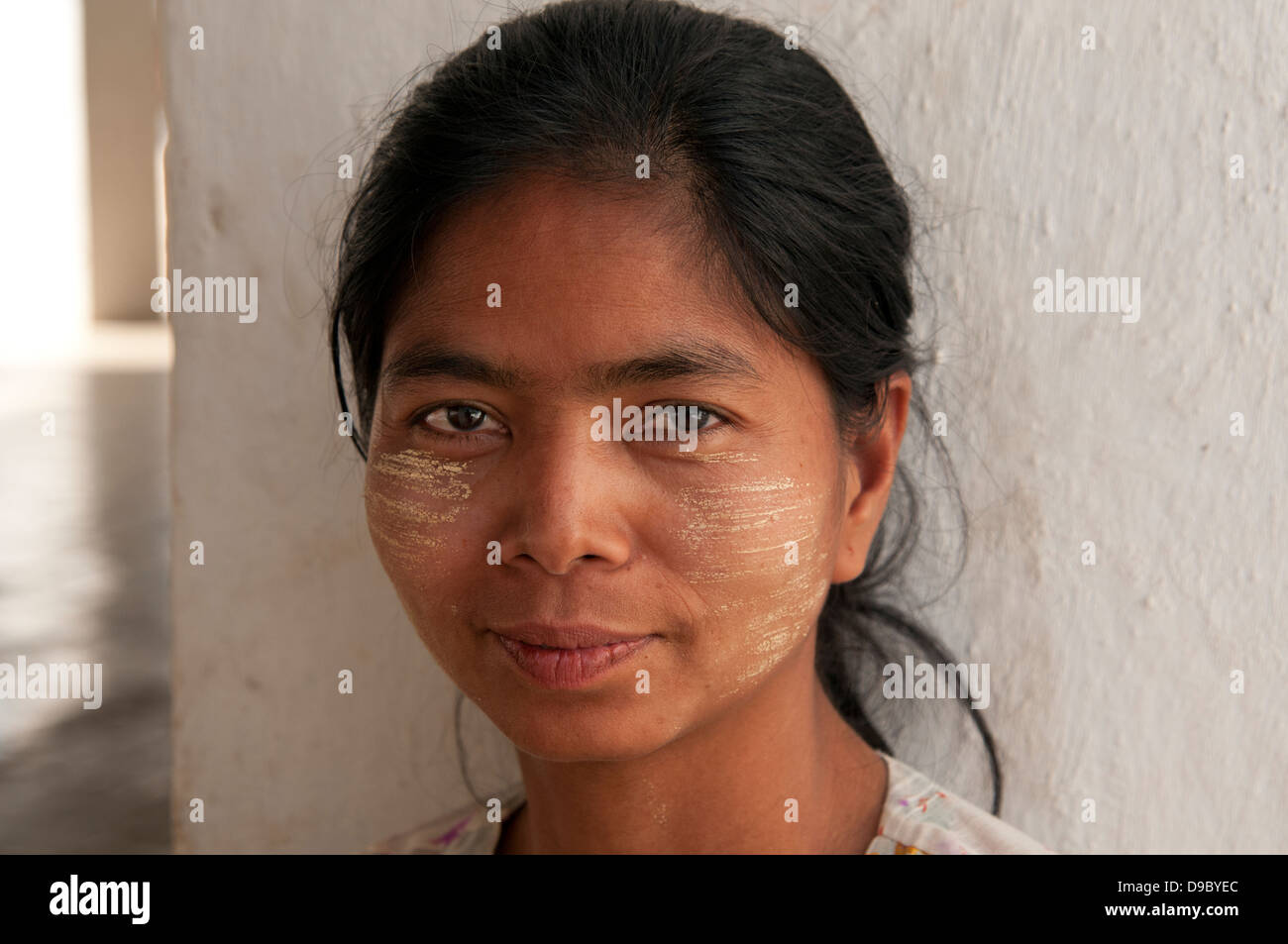 Portrait of a pretty Burmese woman with face covered in thanakha ...