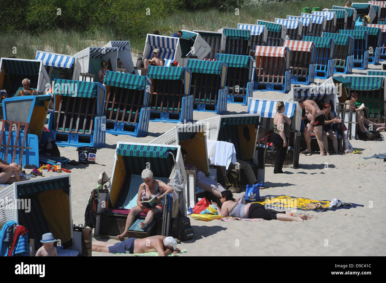 Tourists sit in their beach chairs on the beach in the Baltic Seaside ...