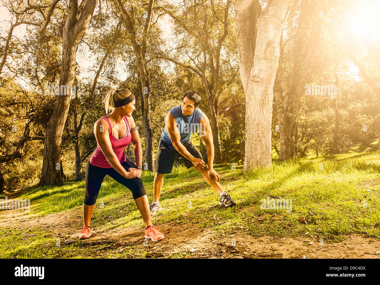 Two people exercising in forest doing warm up stretches Stock Photo - Alamy