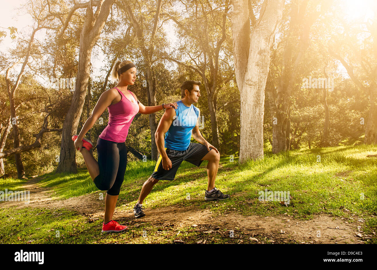Two people exercising in forest doing warm up stretches Stock Photo - Alamy