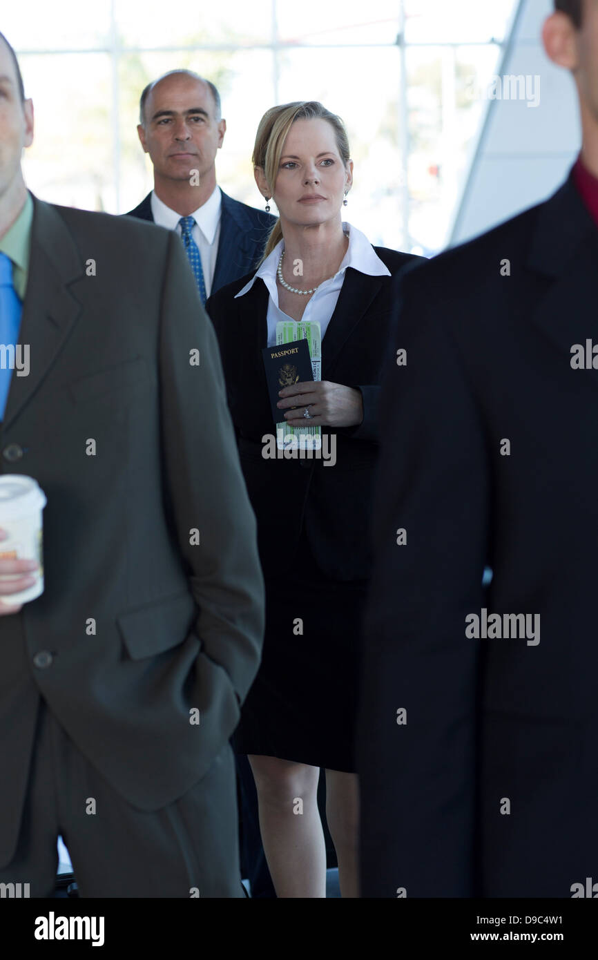 Businesswoman in queue holding passport Stock Photo - Alamy