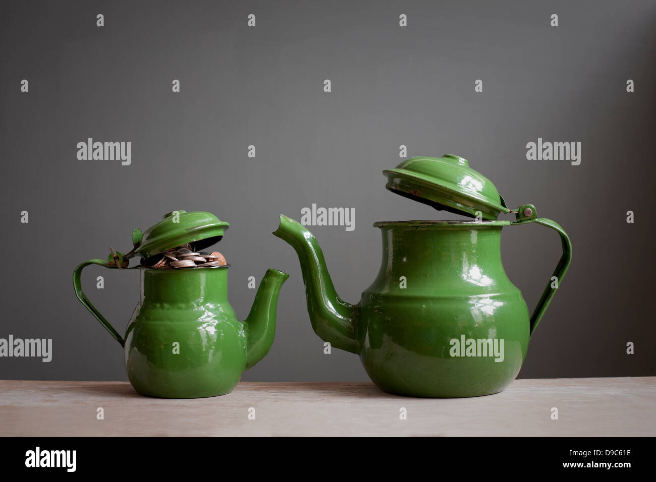 Two teapots with money inside Stock Photo - Alamy