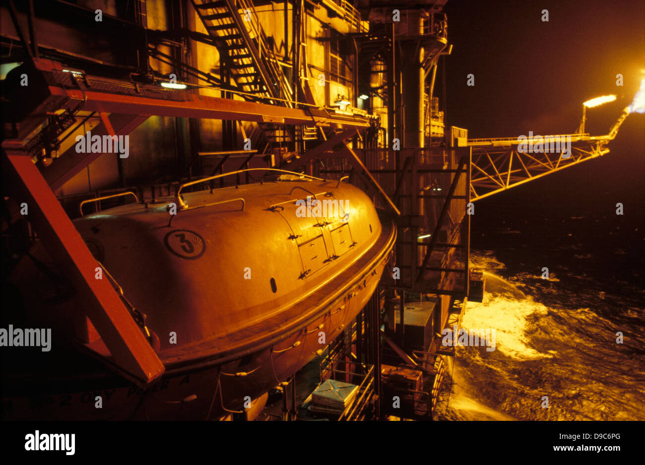 Platform Lifeboat lit by flarestack at night Stock Photo - Alamy