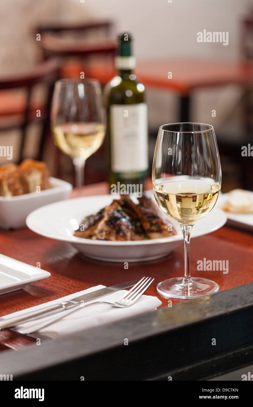 Table set with dish and white wine Stock Photo - Alamy