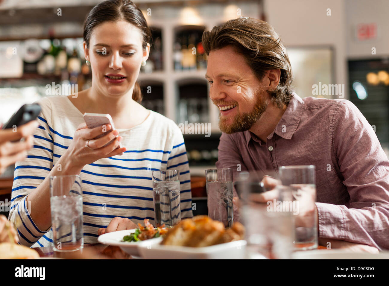 Friends looking at phones restaurant hi-res stock photography and ...