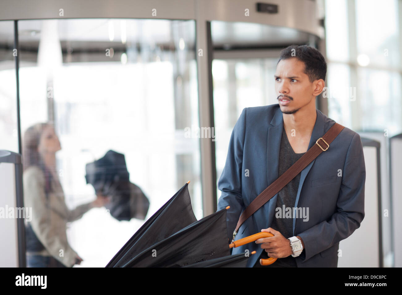Young man arriving with umbrella Stock Photo - Alamy
