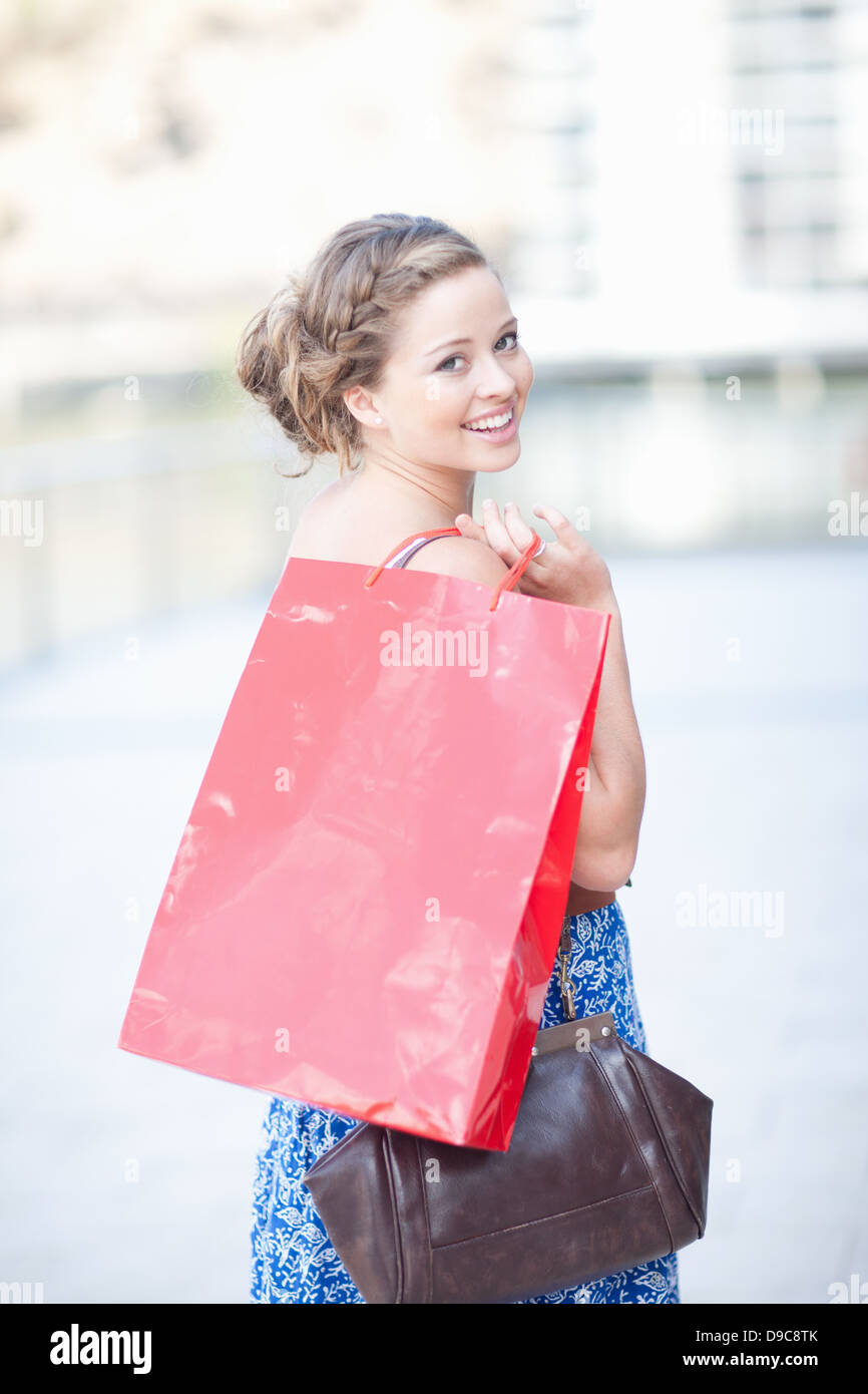 Young woman looking over shoulder at camera Stock Photo - Alamy