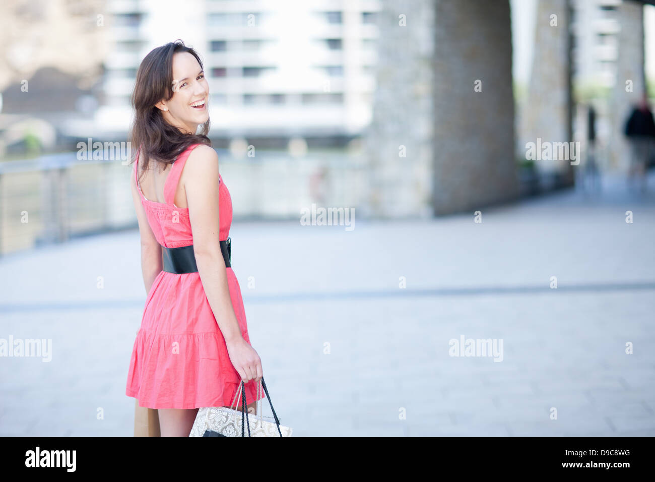 Young woman looking over shoulder at camera Stock Photo - Alamy