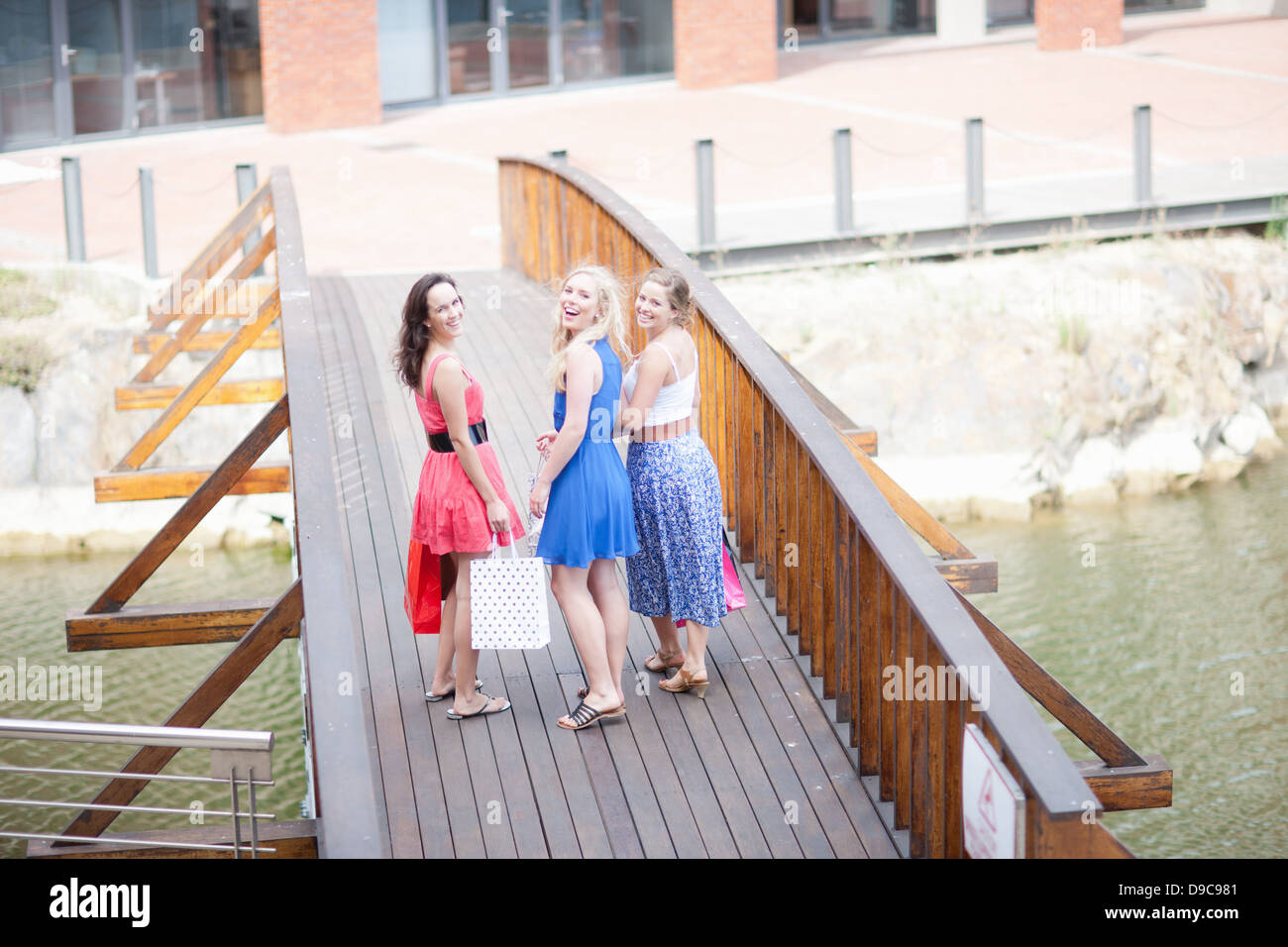 Three young women walking over bridge Stock Photo - Alamy