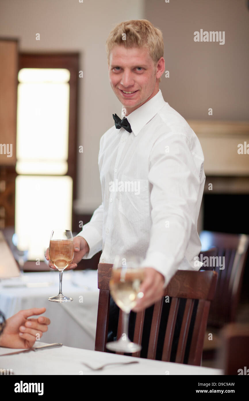 Waiter serving white wine in restaurant Stock Photo - Alamy
