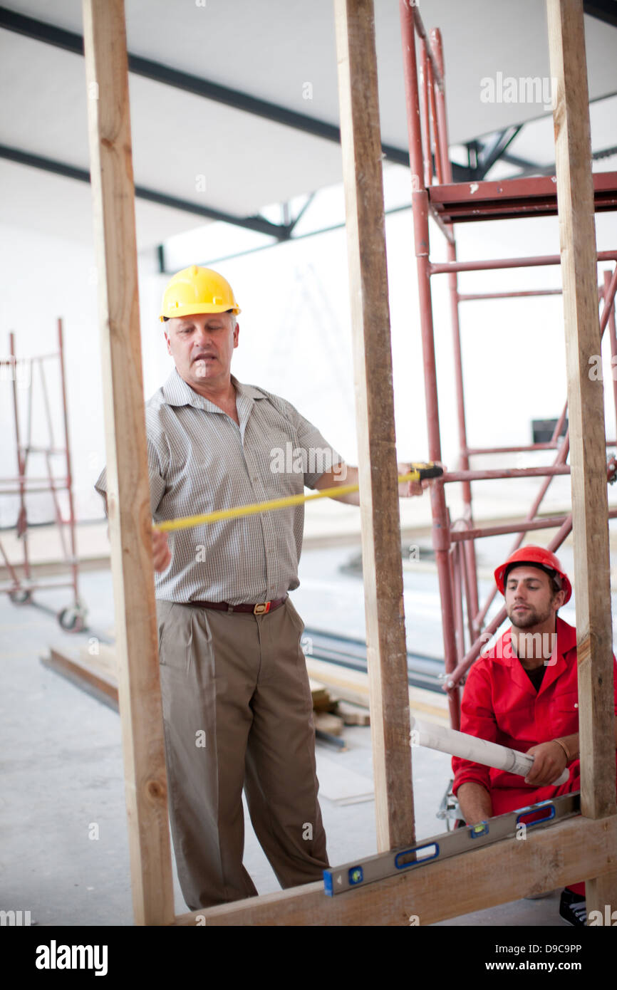 Builder and project manager measuring construction frame Stock Photo ...