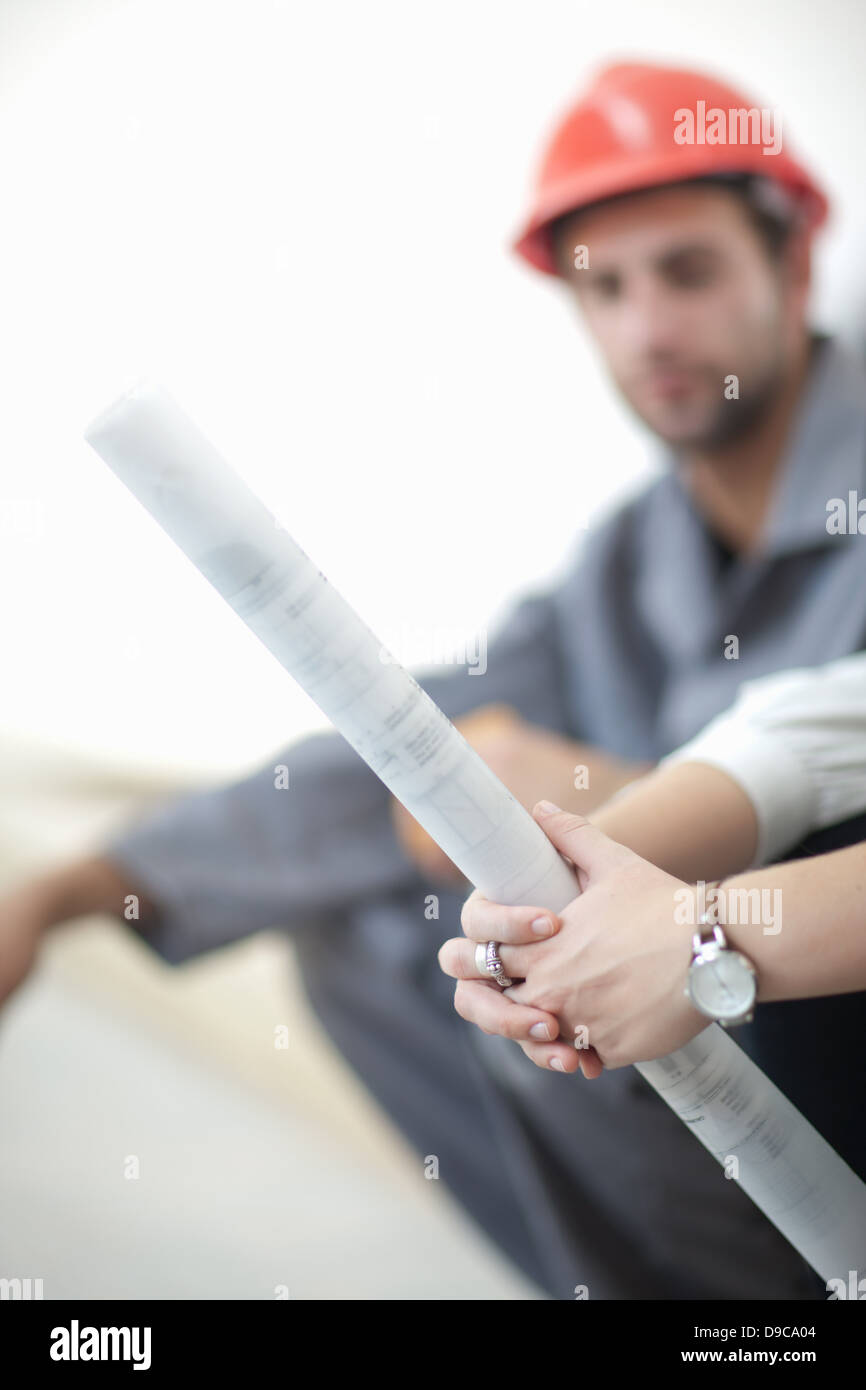 Female architect holding blueprint Stock Photo - Alamy