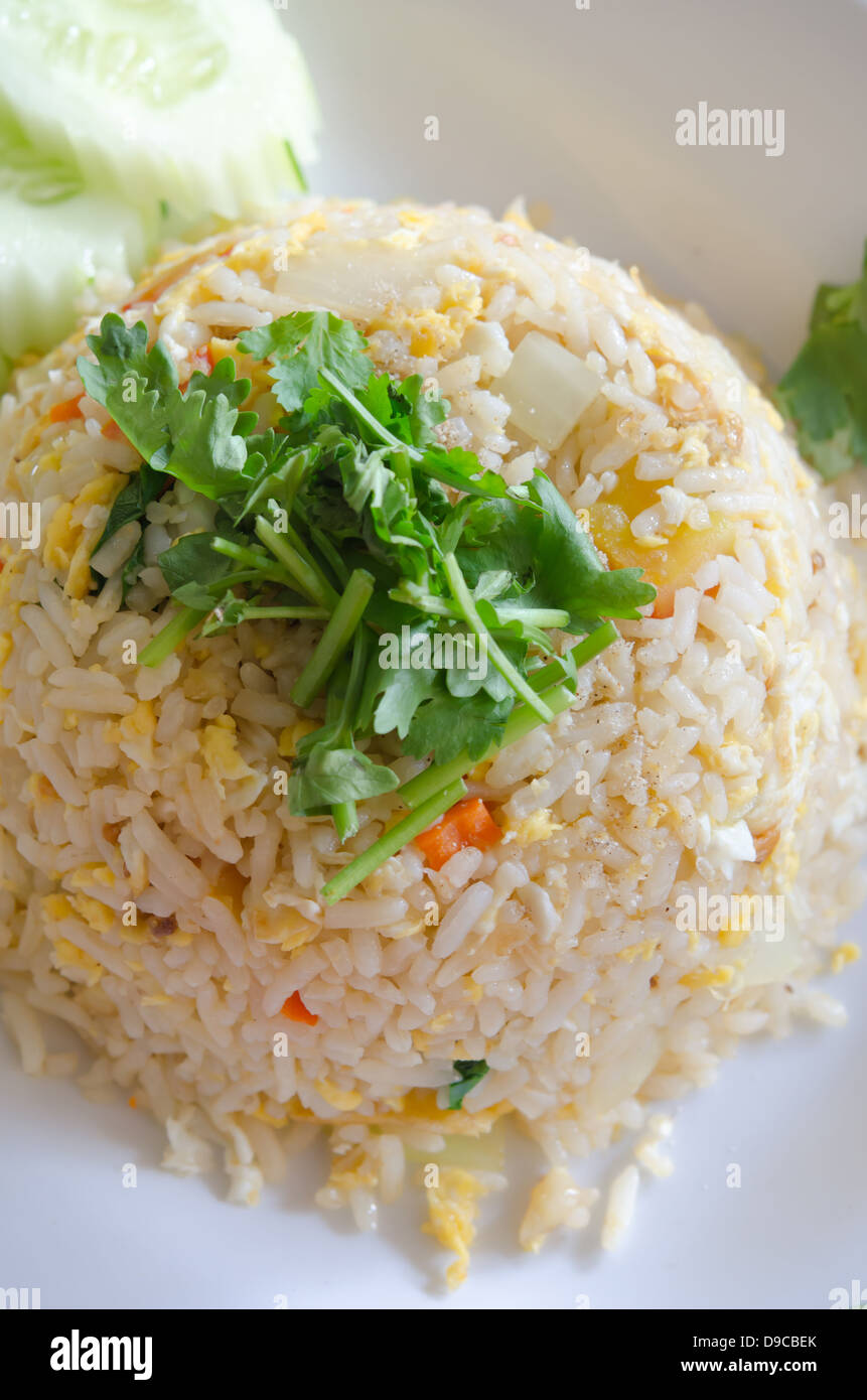 top view fried rice served with fresh cucumber slices on white plate ...