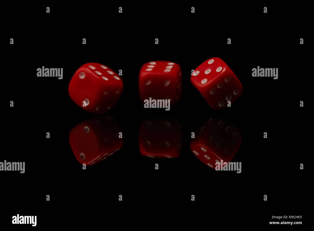three red dice on a black background with clear reflections Stock Photo ...