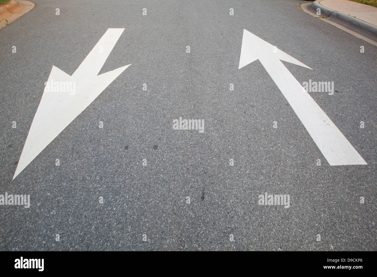 White directional arrows on pavement Stock Photo - Alamy