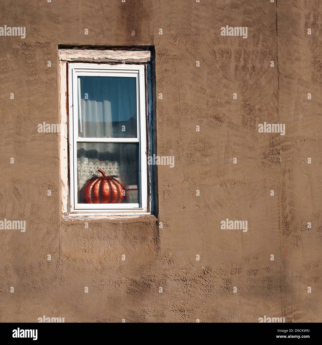 A distressed old window with a vintage copper pumpkin shaped mold, in ...