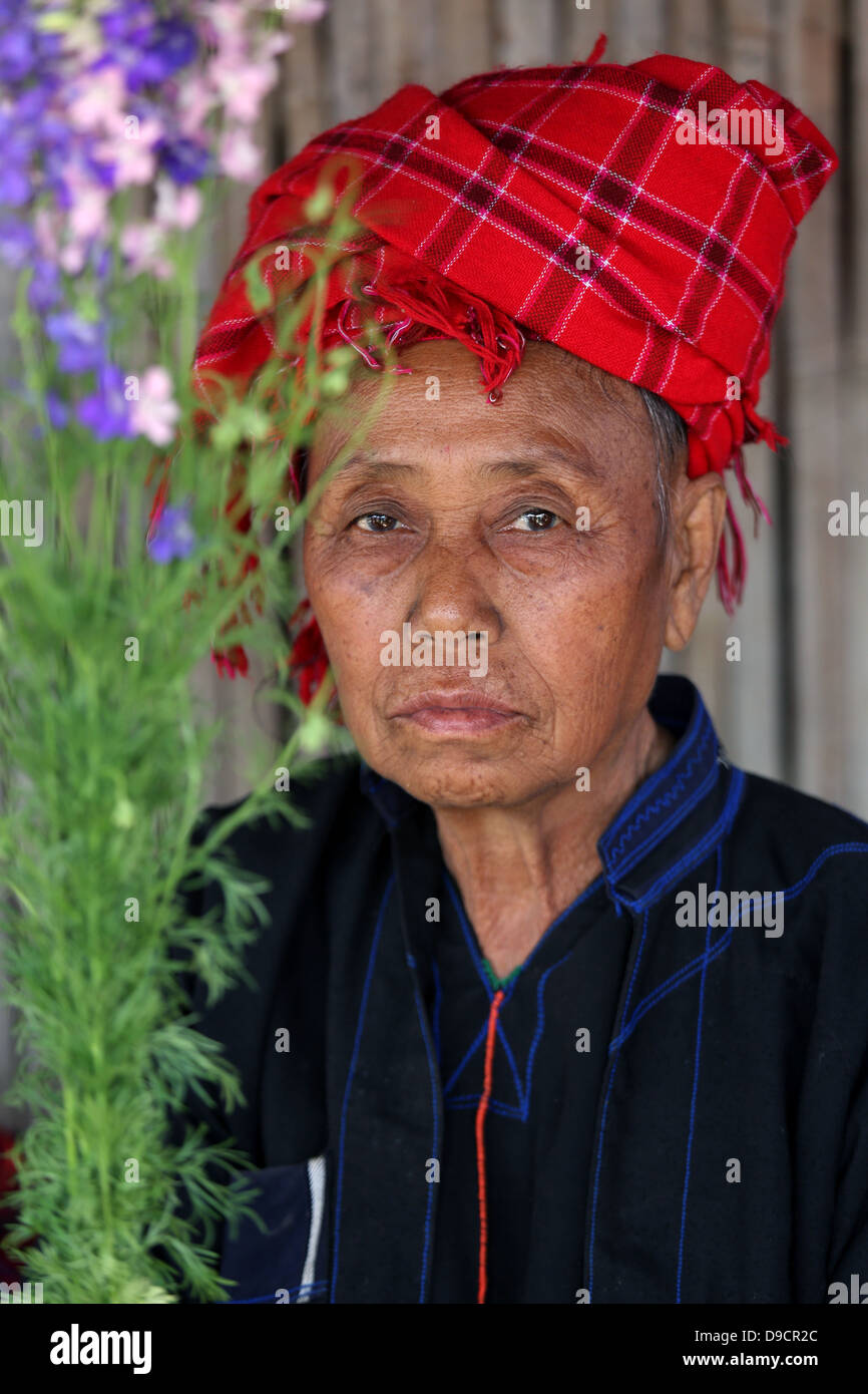 Portrait of woman holding flowers in red cloth turban from Shan Tribe ...