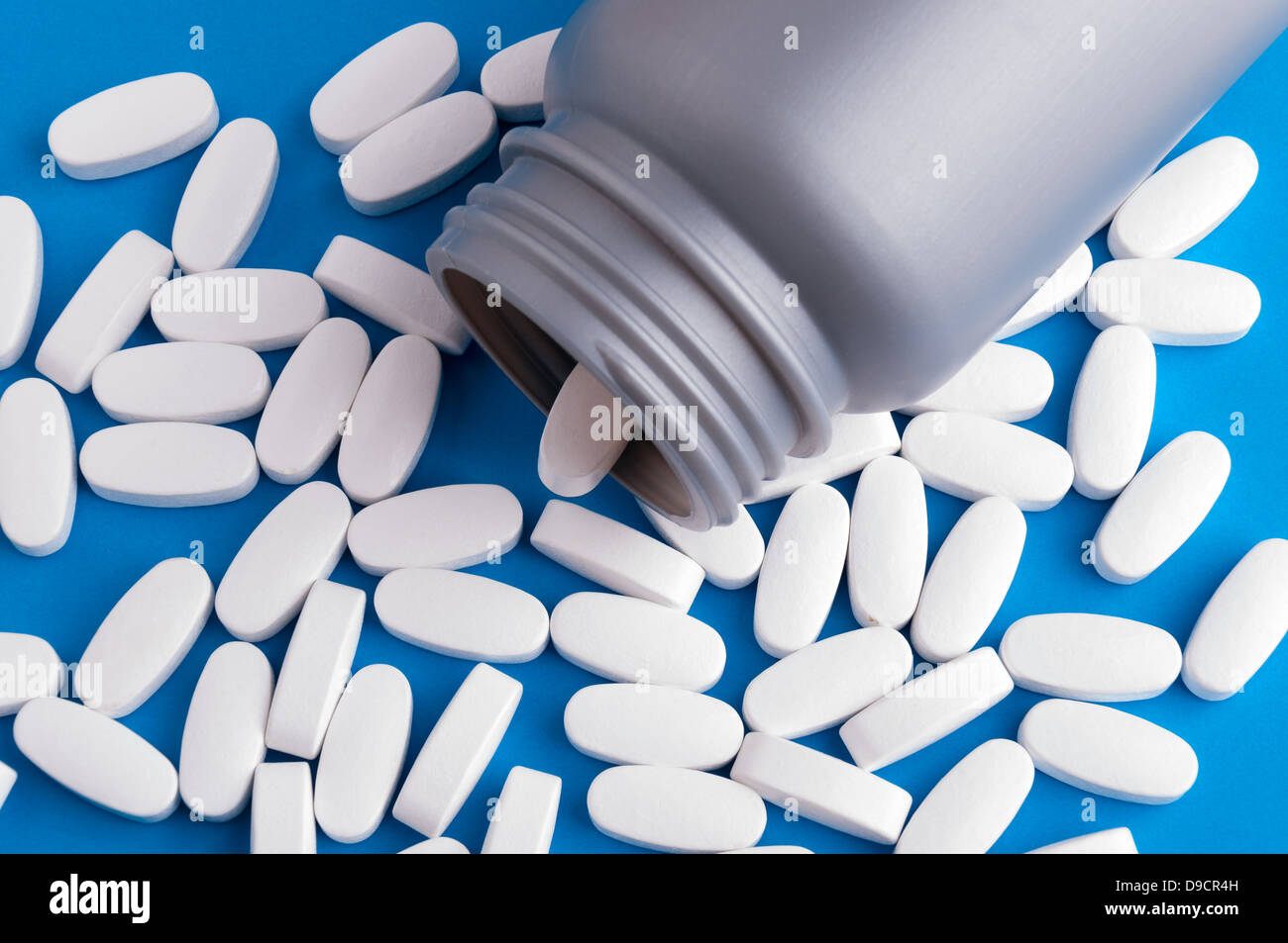 Recipient of medication pills on blue background Stock Photo - Alamy