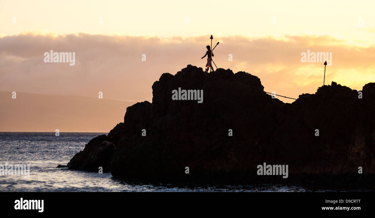 Cliff diver carries torch on top of Black Rock at Kaanapali Beach, Maui ...