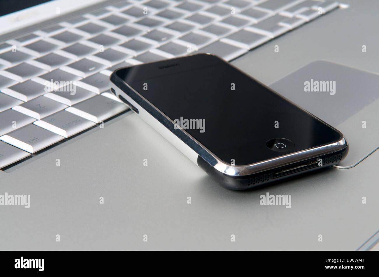 Cell phone on computer laptop Stock Photo - Alamy