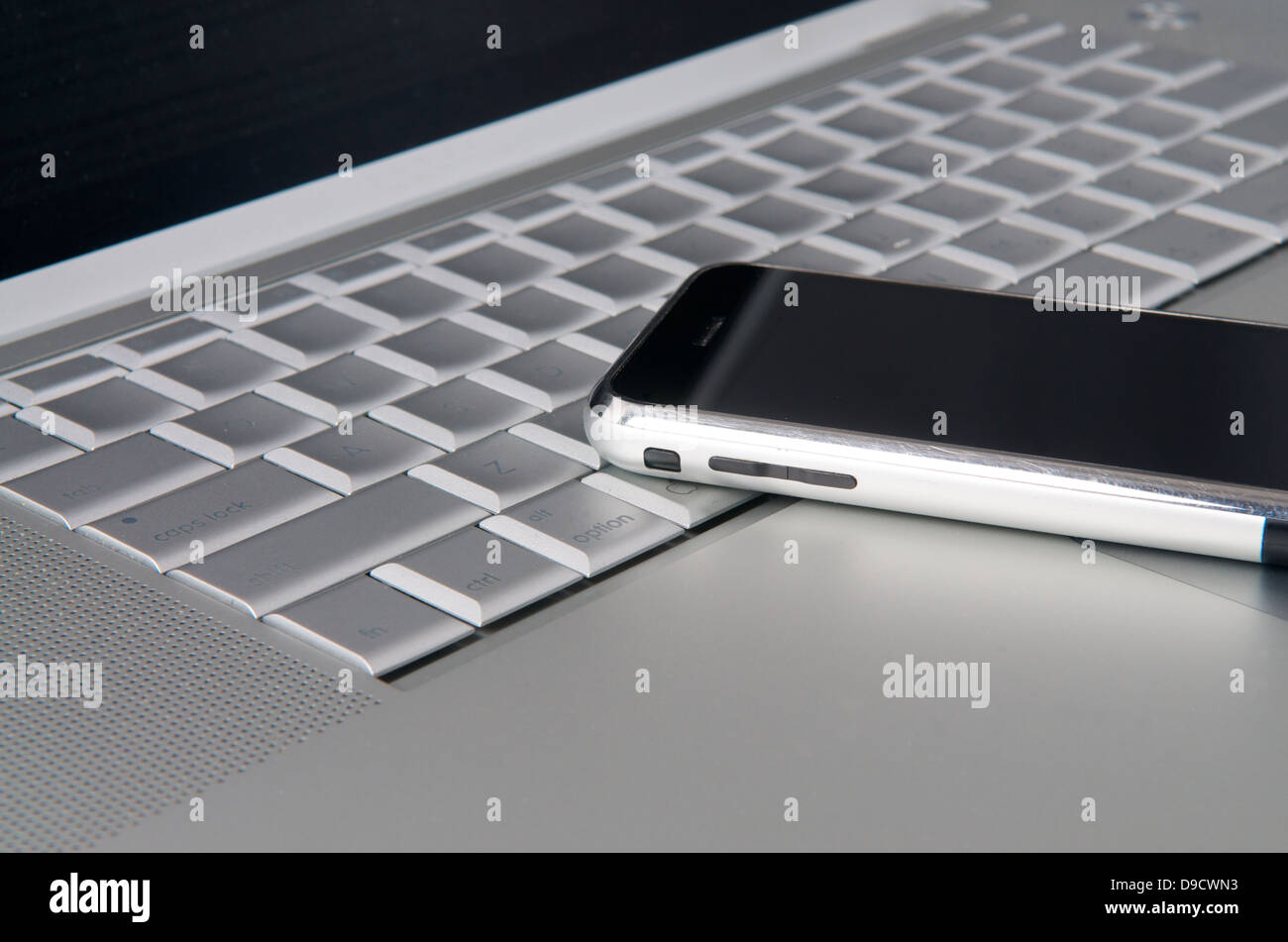 Cell phone on computer laptop Stock Photo - Alamy
