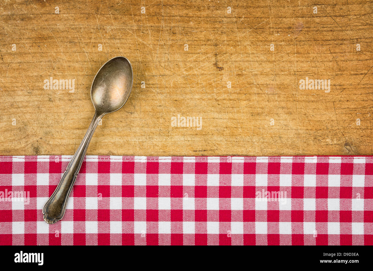 Silver spoon on a wooden board with a checkered tablecloth Stock Photo ...