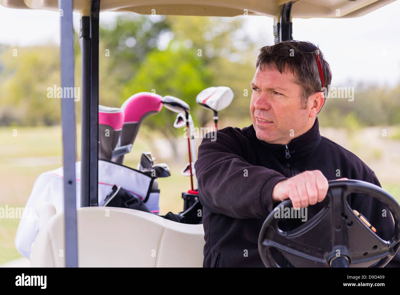 Mature man riding cart on golf course Stock Photo - Alamy