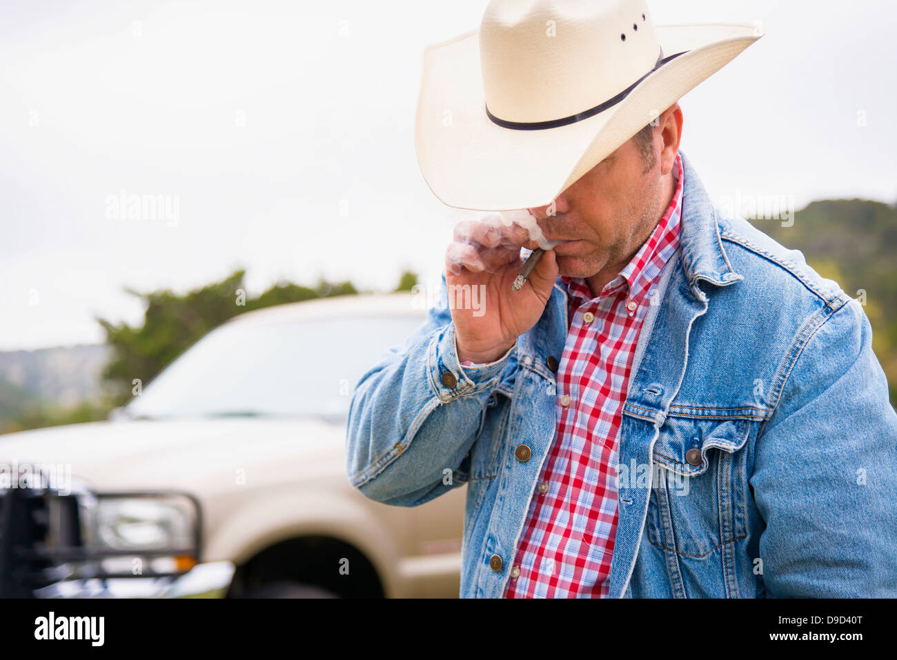 Texas, Cowboy smoking cigar, pick up truck in background Stock Photo ...