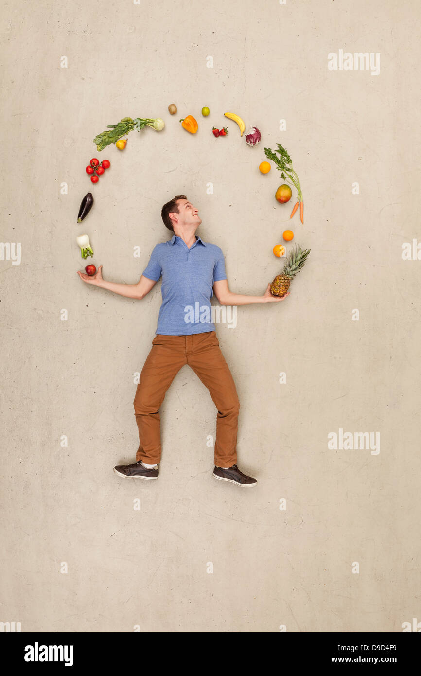 Man juggling food against beige background Stock Photo - Alamy