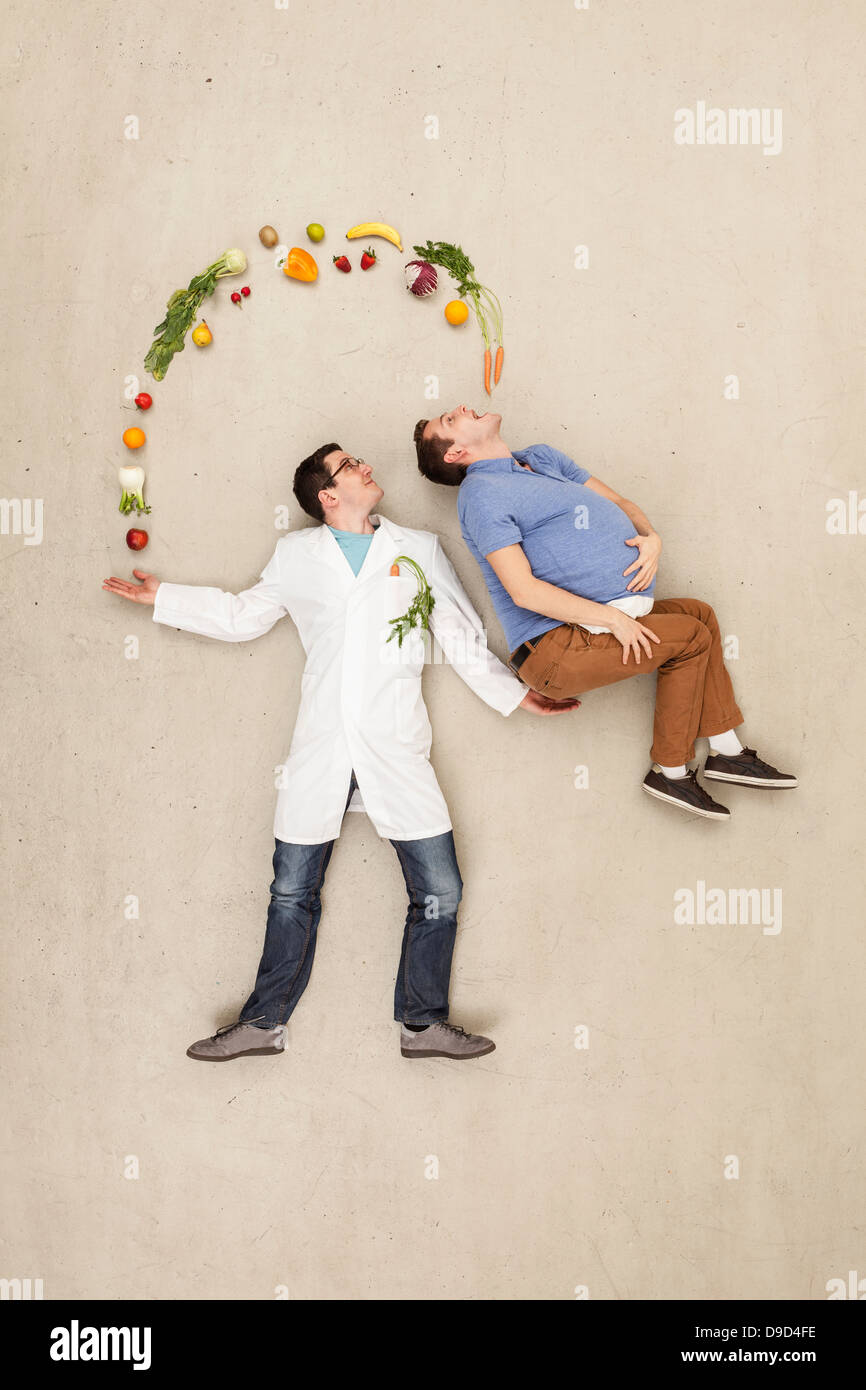 Man throwing fruits in another mans mouth Stock Photo - Alamy