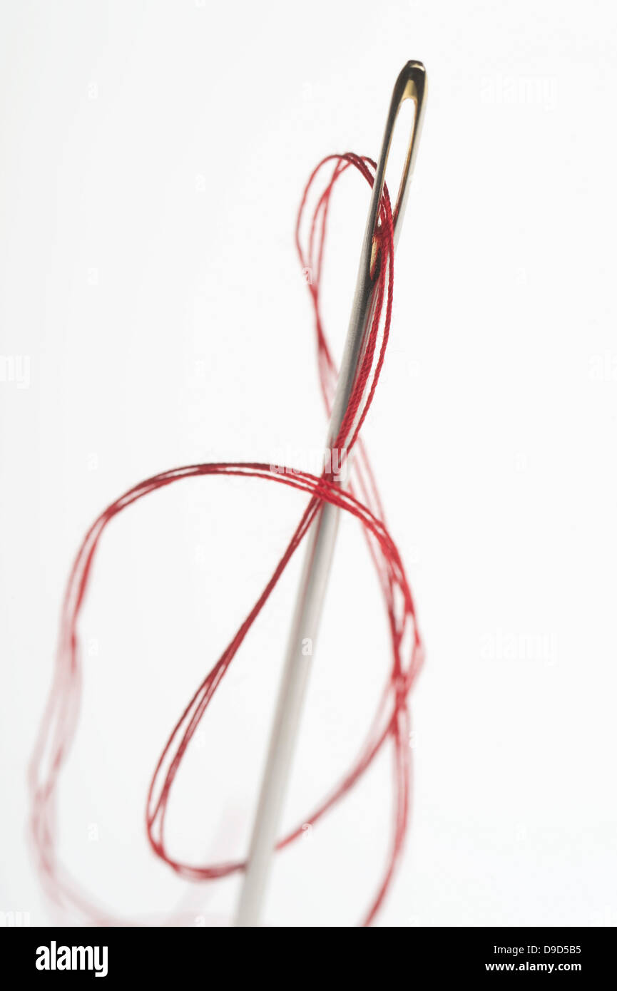 Thread passing through needle eye hi-res stock photography and images ...