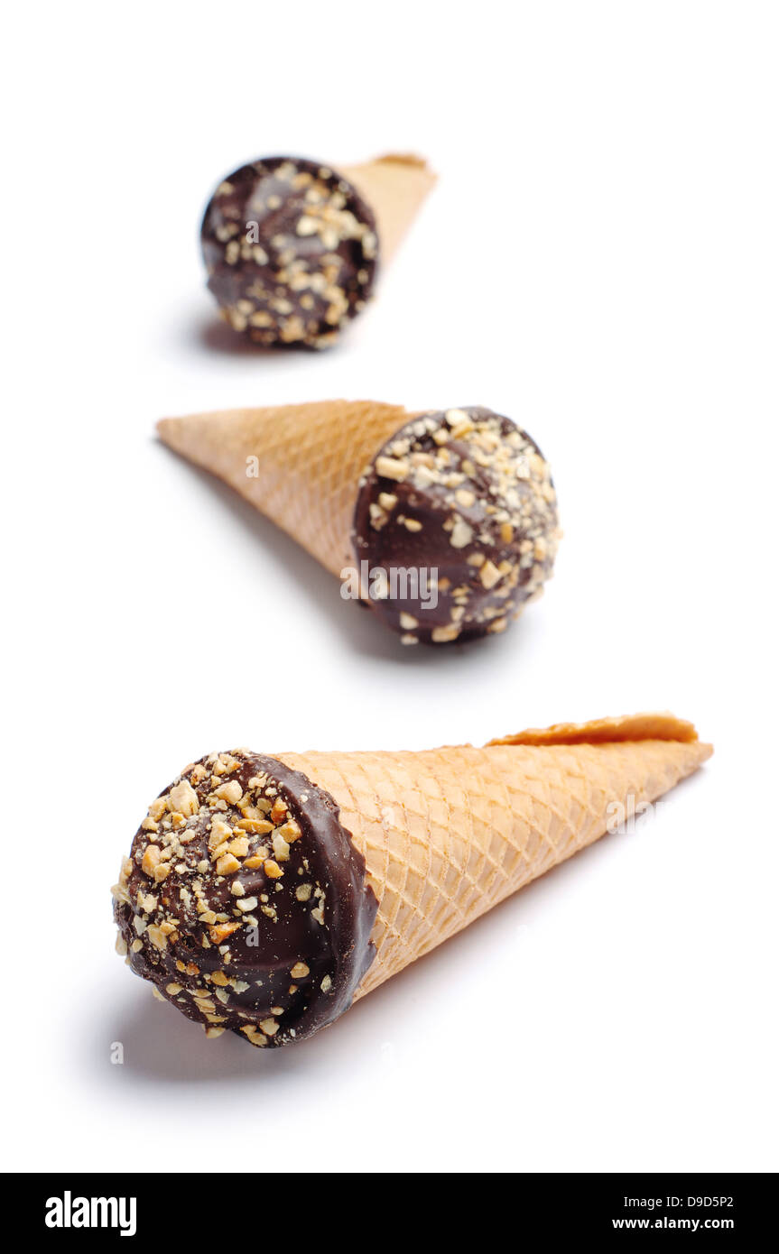 Three sweet cakes in cream cone on white Stock Photo - Alamy