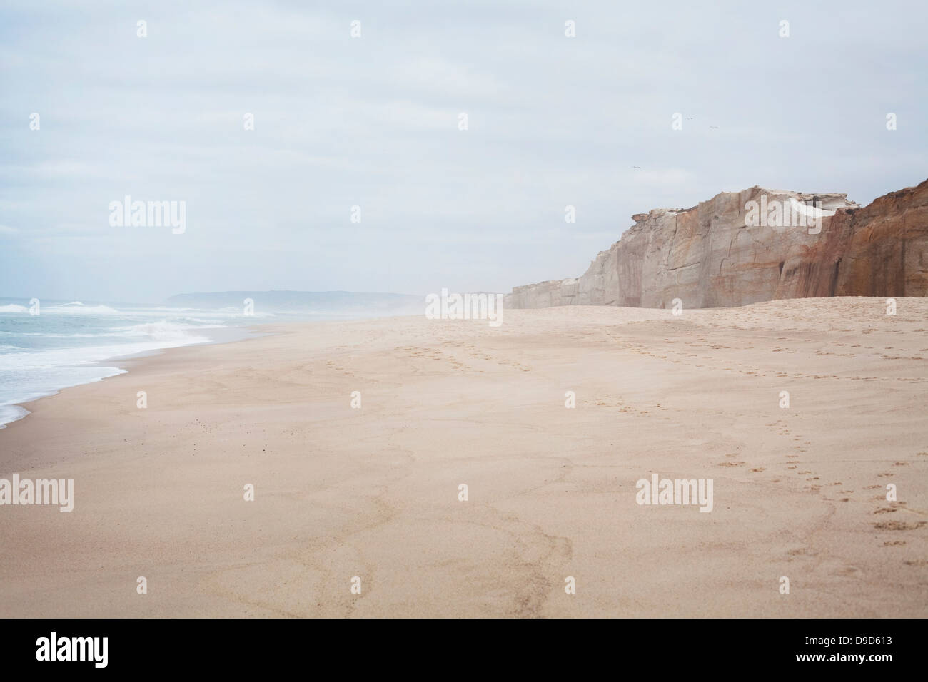 Peaceful beach scene with cliffs Stock Photo - Alamy
