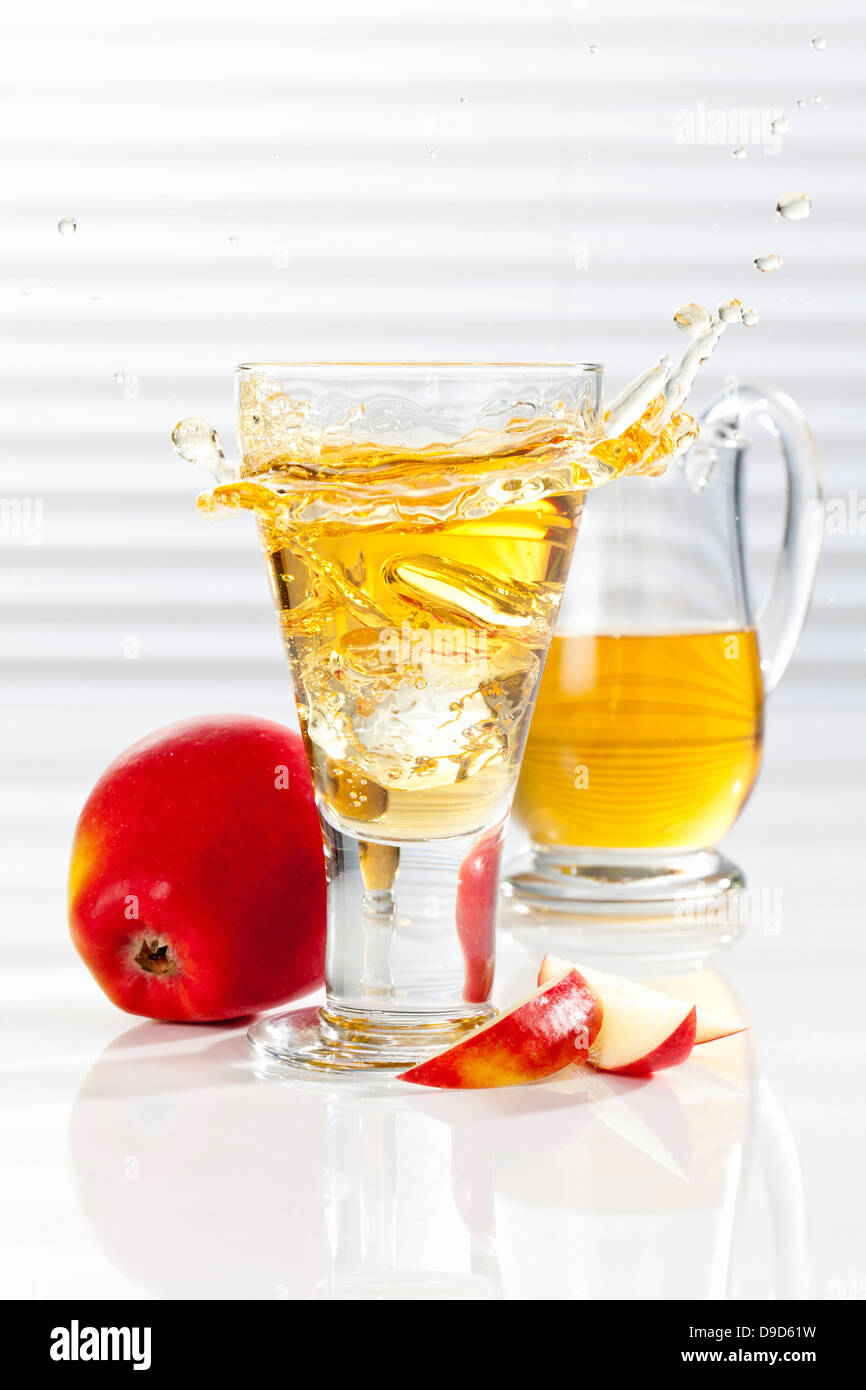 Carafe and glass with splashing apple juice, close up Stock Photo - Alamy