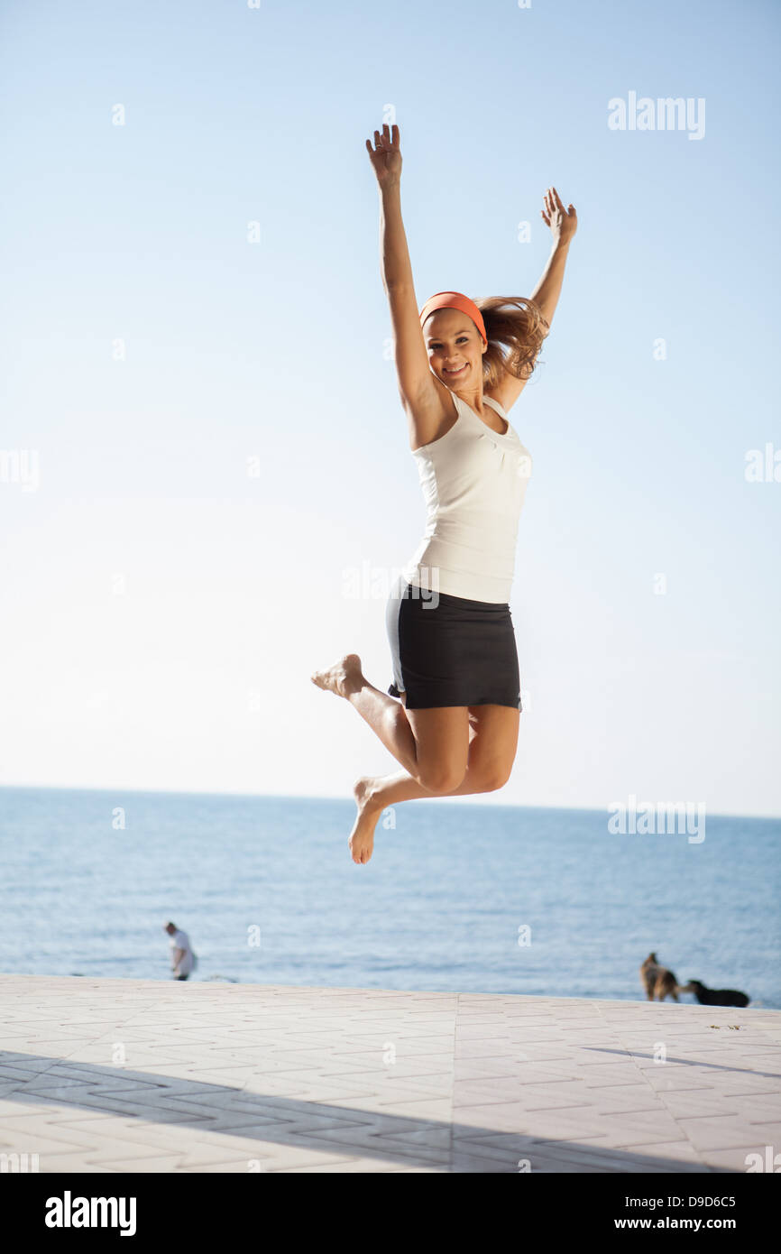 Young woman jumping mid air Stock Photo - Alamy