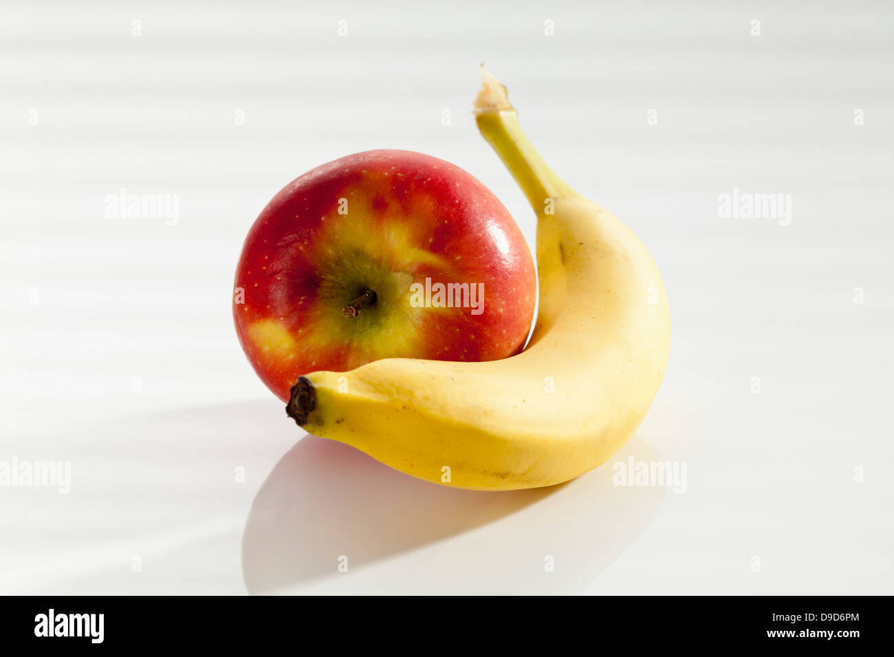 Banana with apple on white background, close up Stock Photo - Alamy