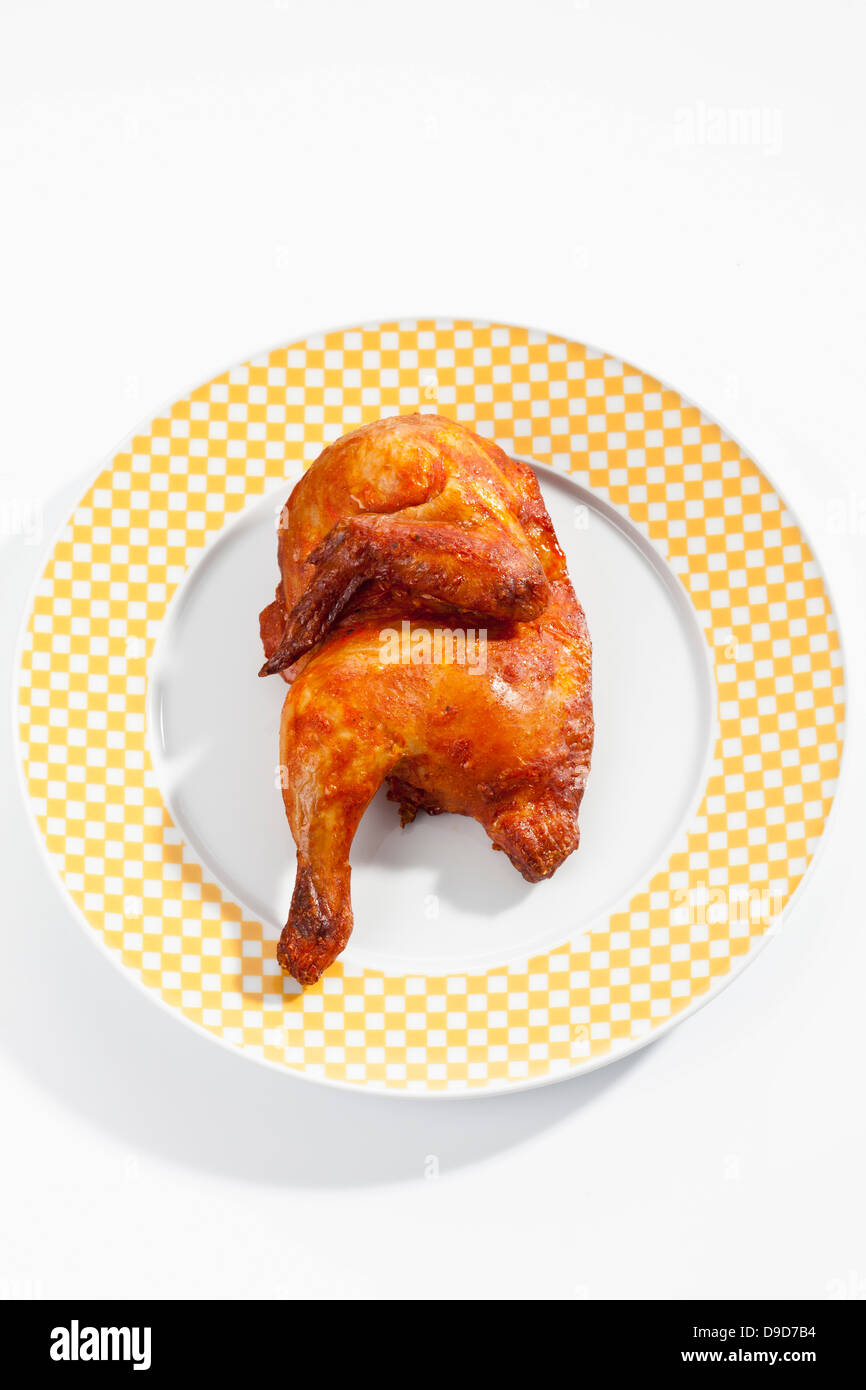 Plate of half roasted chicken on white background Stock Photo - Alamy
