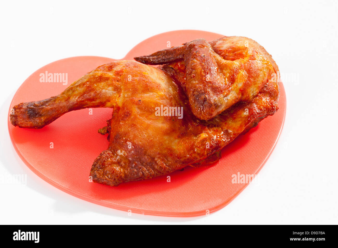 Plate of half roasted chicken on white background Stock Photo - Alamy