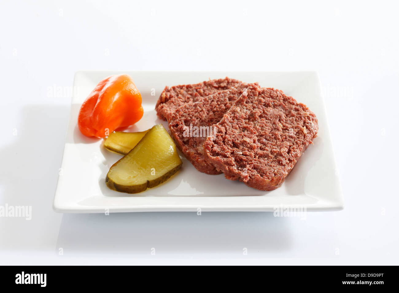 Slice of beef and corn in plate on white background, close up Stock ...